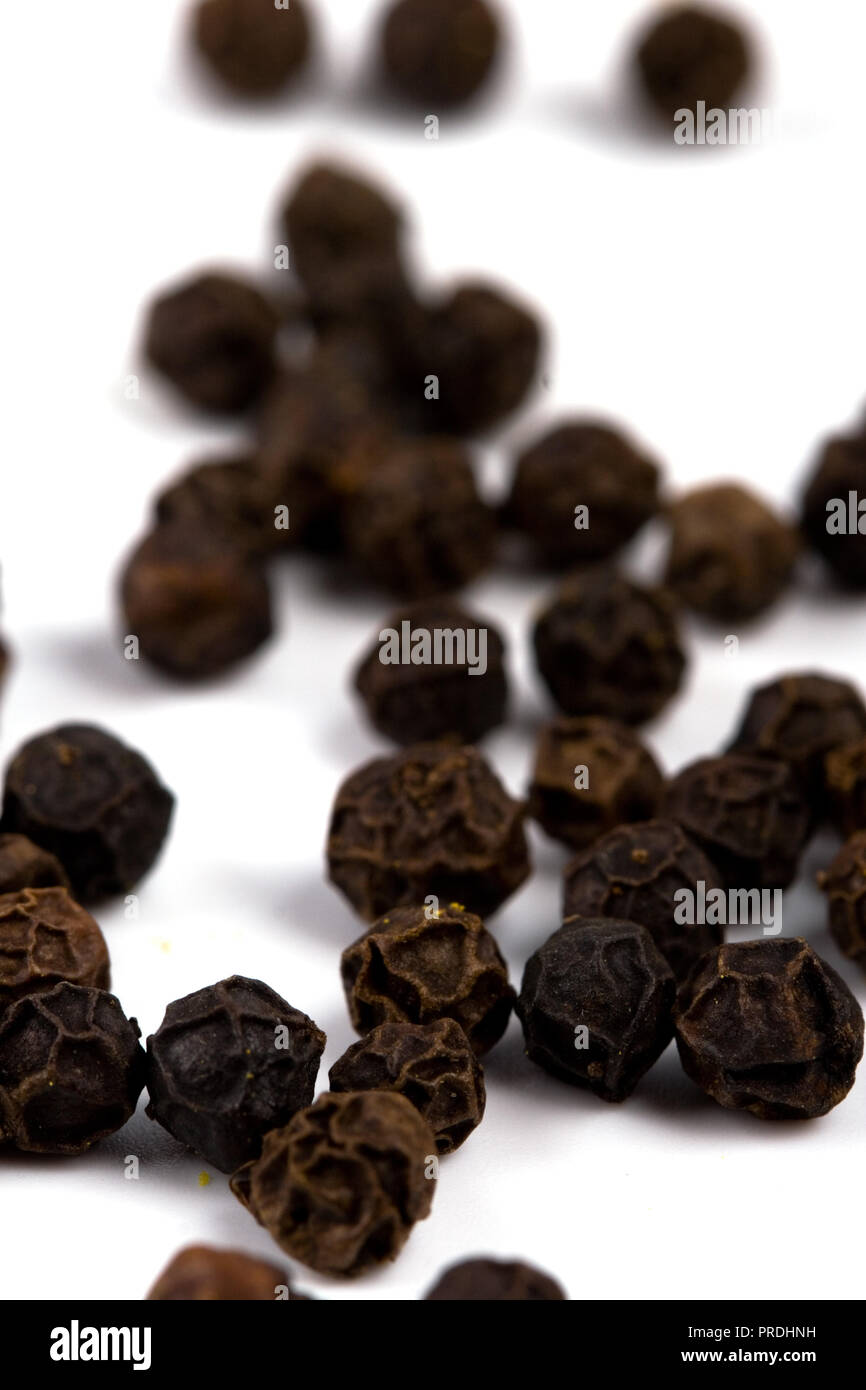 black pepper closeup on white background Stock Photo - Alamy
