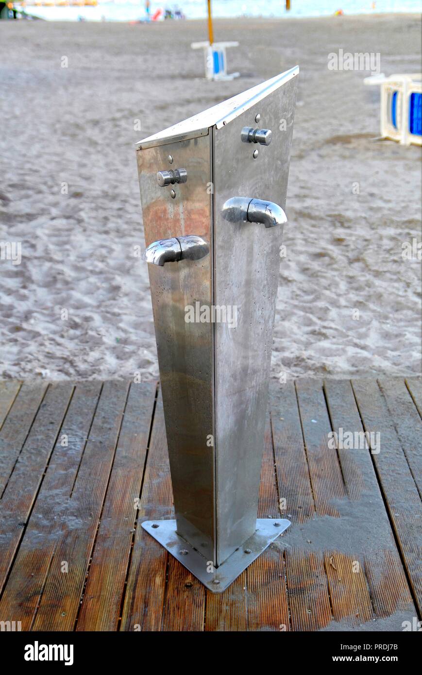 Public foot washing station wooden decking on a sandy beach, for ...
