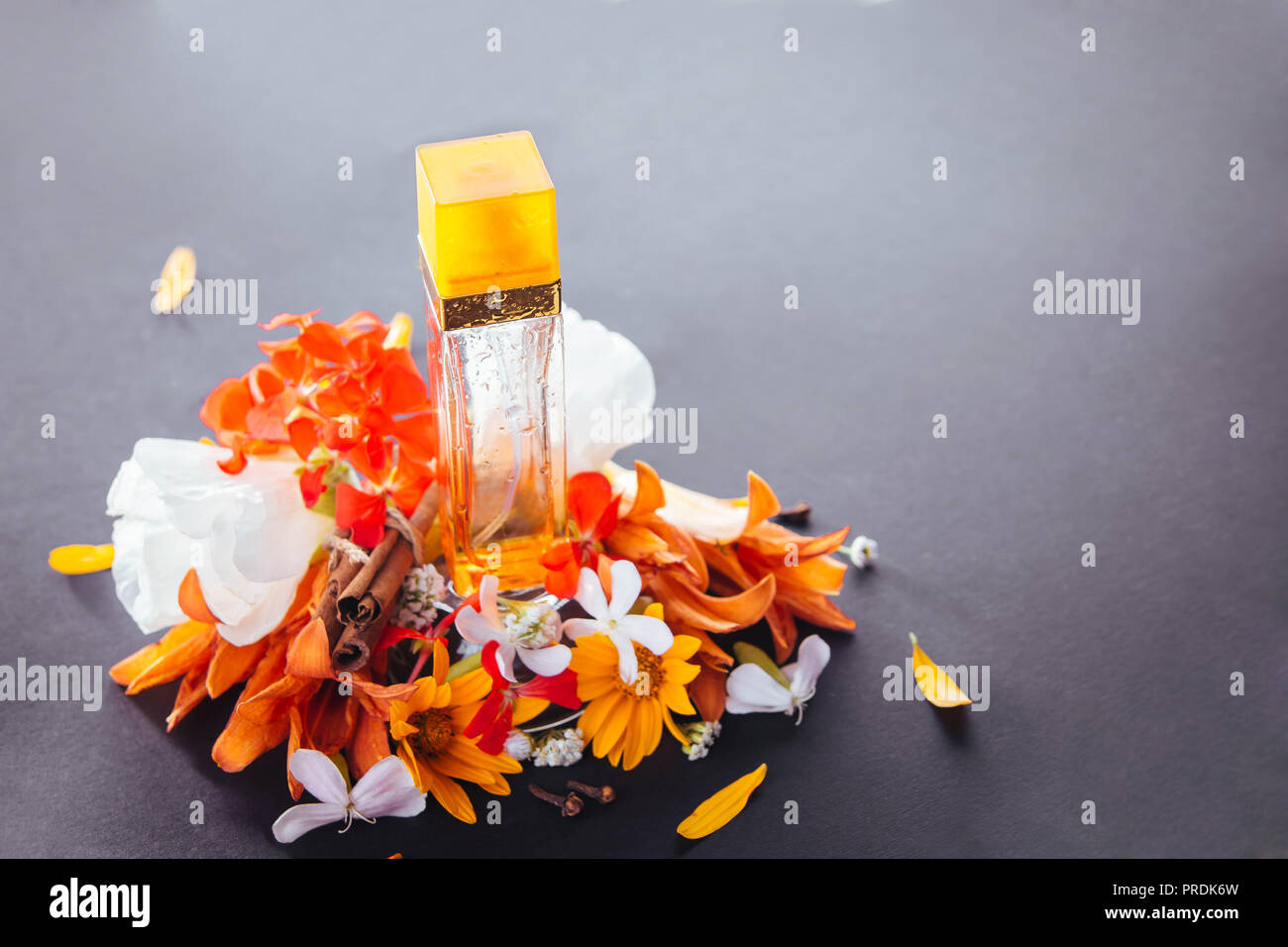 Bottle of perfume with ingredients on black background Stock Photo - Alamy