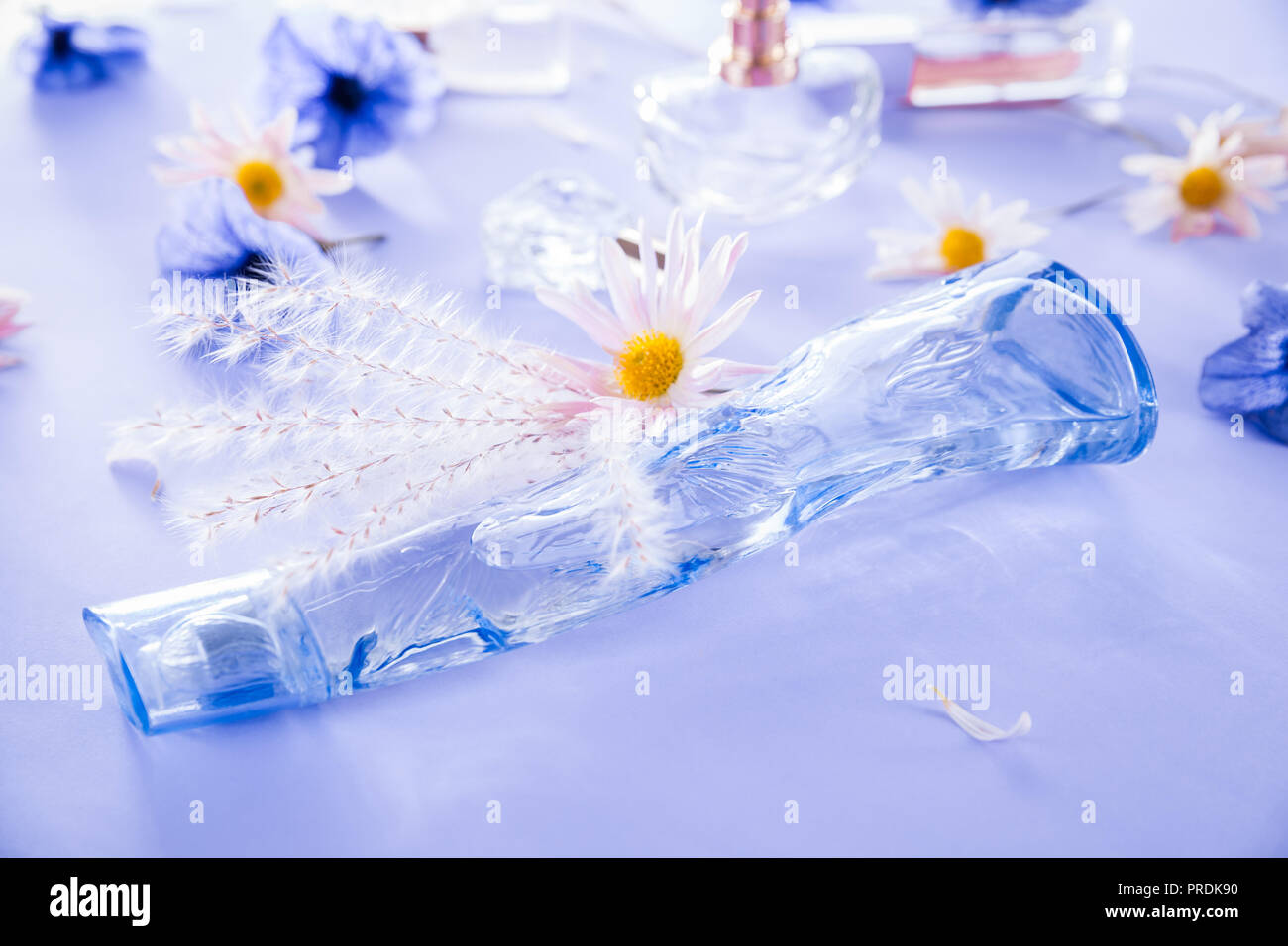 Bottles of perfume with flowers on blue background Stock Photo - Alamy