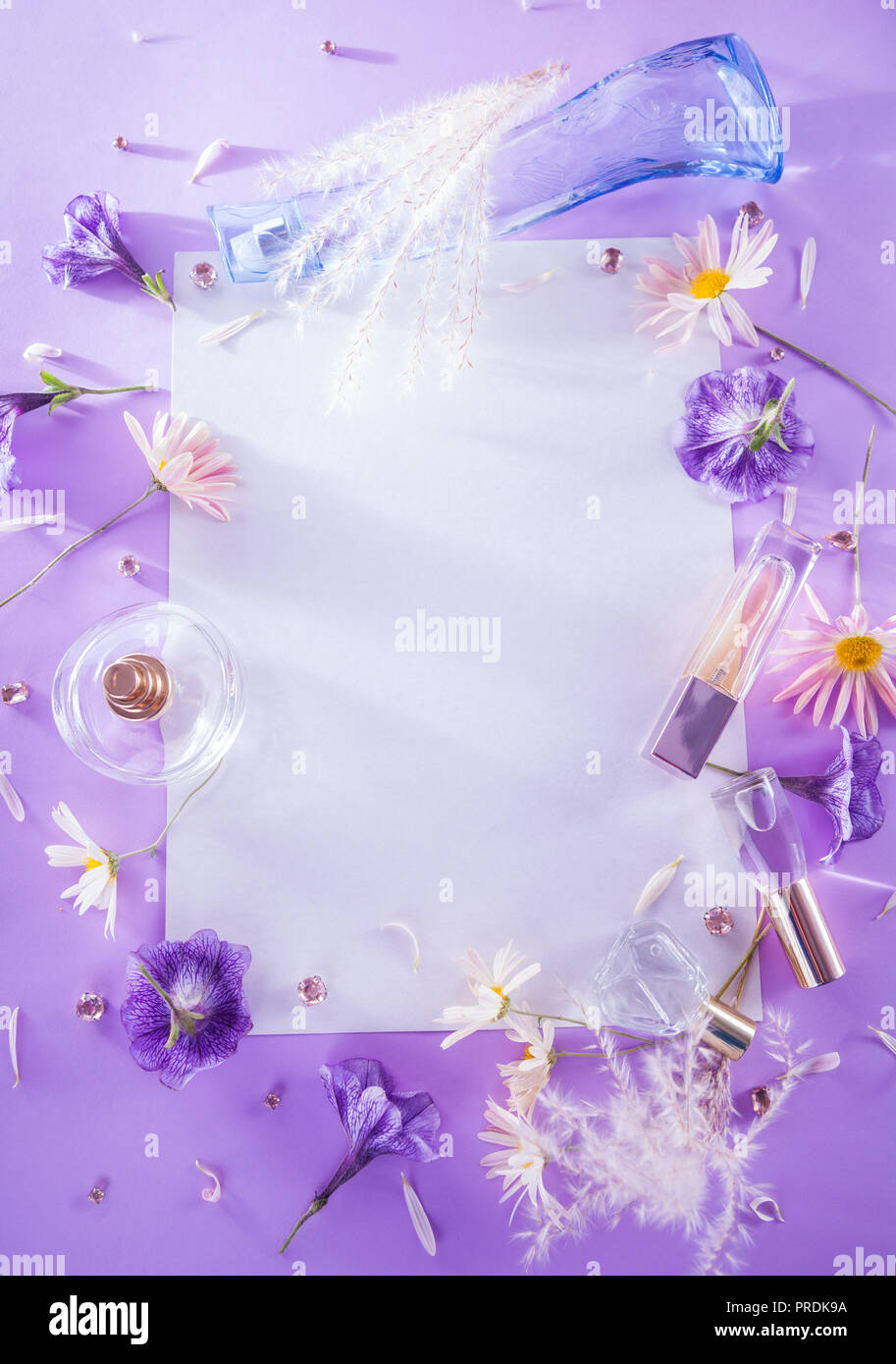 Bottles of perfume with flowers on purple background Stock Photo - Alamy