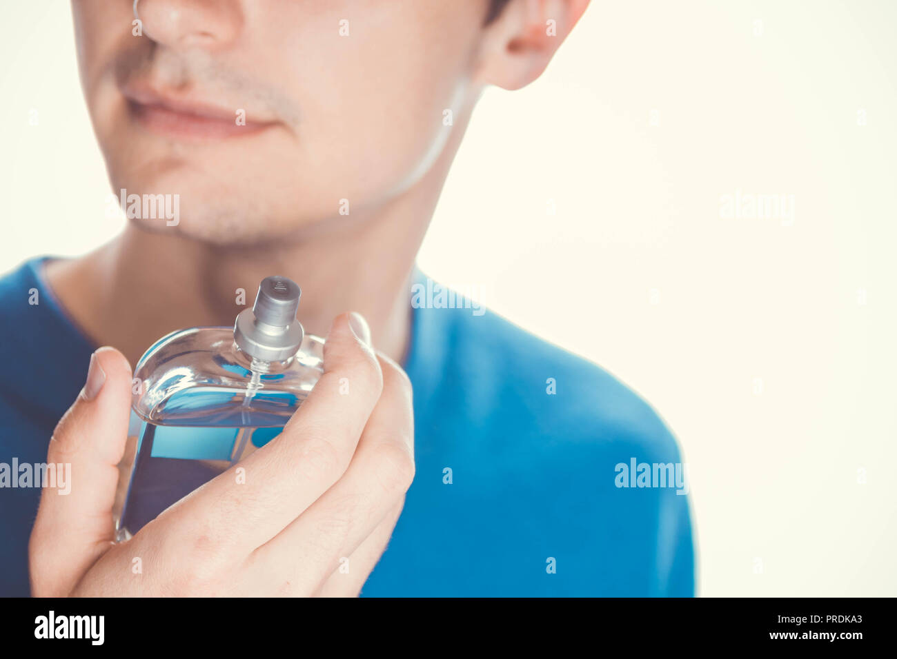 Young man applying perfume on his neck Stock Photo - Alamy