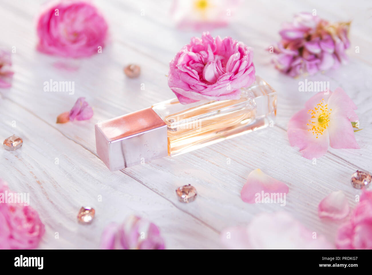Bottle of perfume with flowers on white background Stock Photo - Alamy