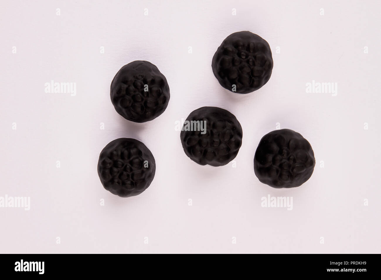 Black gummy candies on white background Stock Photo - Alamy