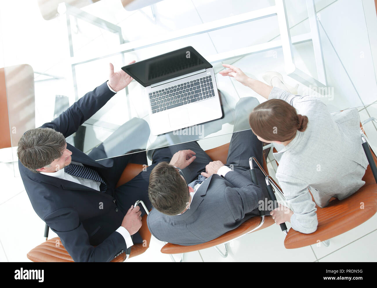 Three business people, meeting around a boardroom table Stock Photo - Alamy