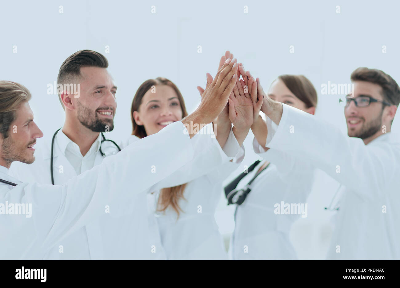 group of doctors giving each other a high five Stock Photo - Alamy