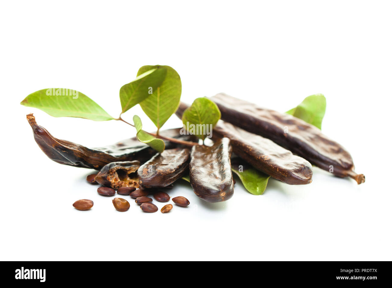Carob. Healthy organic sweet carob pods with seeds and leaves on white ...