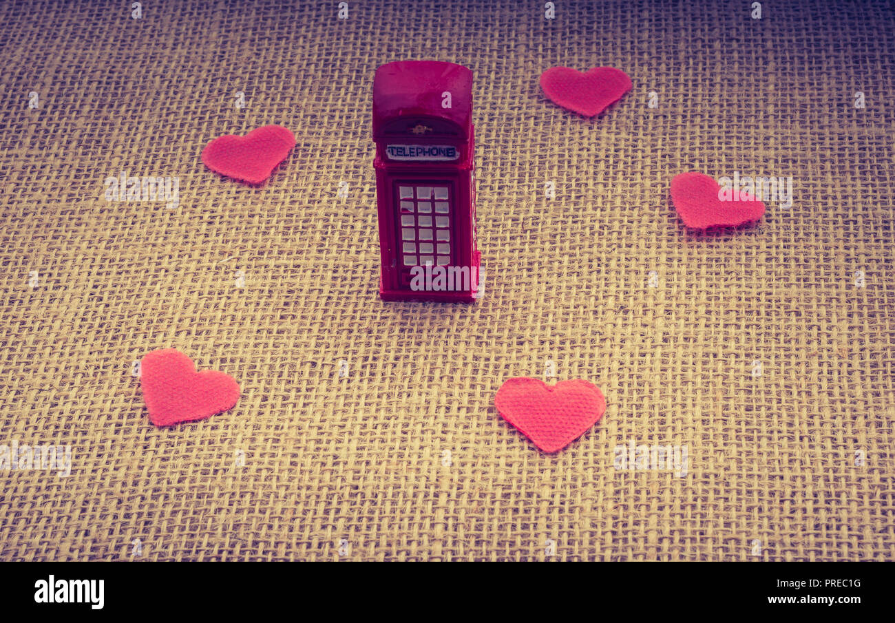 Red hearts around red color phone booth on canvas Stock Photo - Alamy