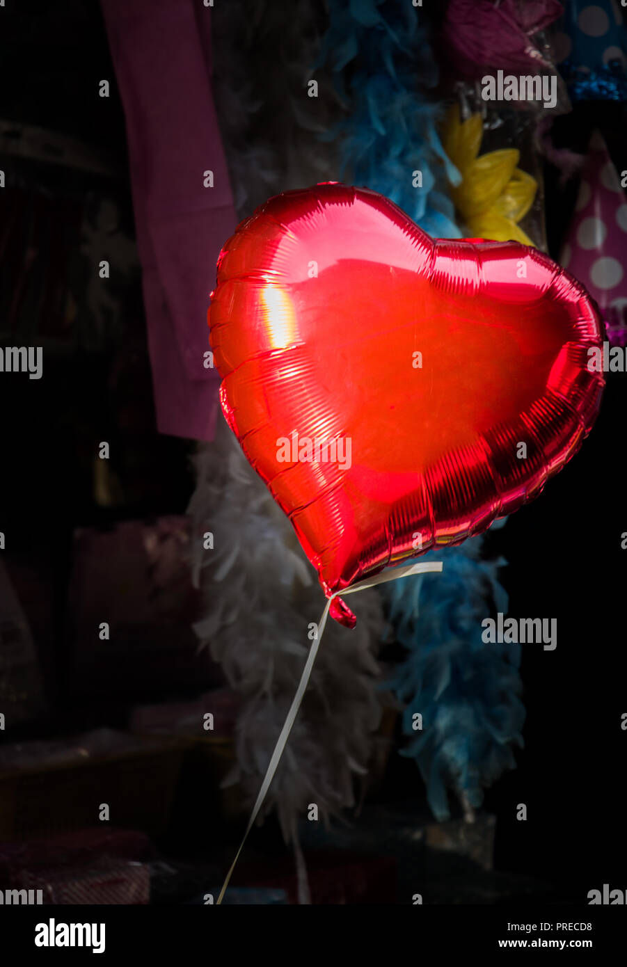 Little red color heart shape balloon in a bazaar Stock Photo - Alamy