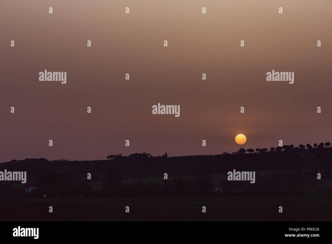 Sunset with sand suspended in the atmosphere, coluring the sky red ...