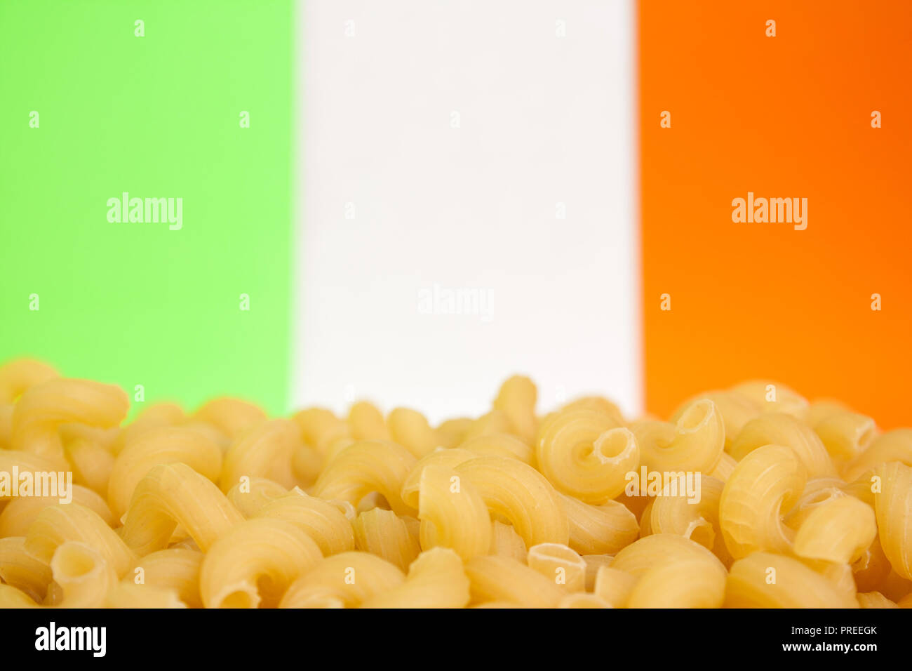Texture of amorini or pasta against the background of the Italian flag ...