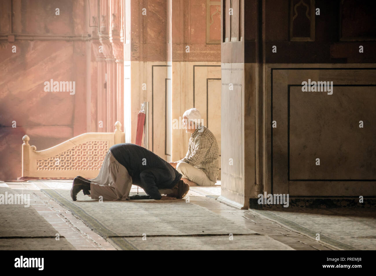 Religious muslim man praying inside the mosque. Two older Muslims at ...