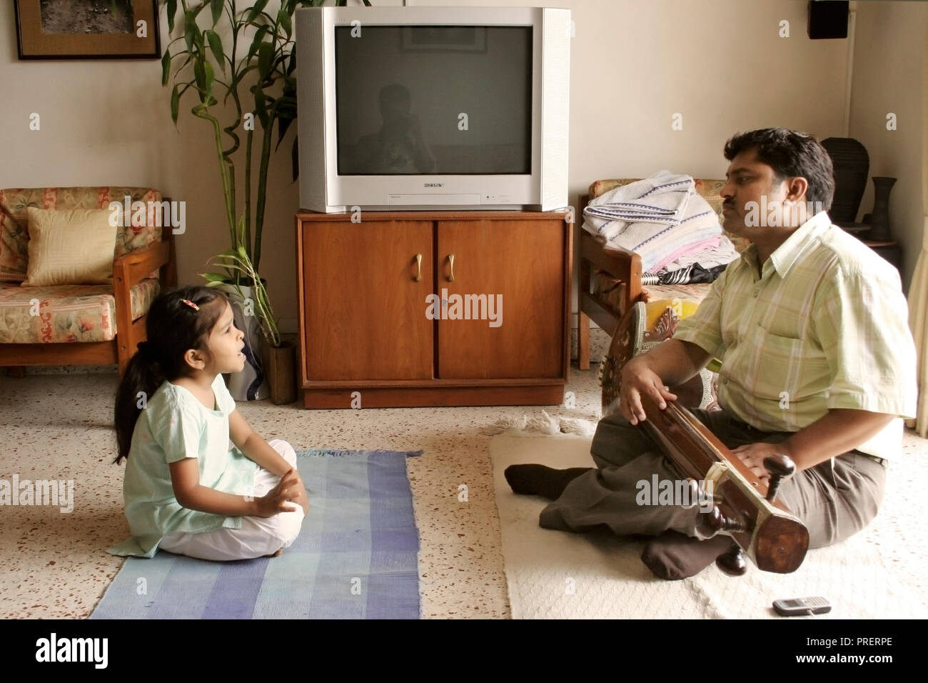YOUNG GIRL LEARNING MUSIC ON A KEYBOARD FROM A TEACHER Stock Photo - Alamy