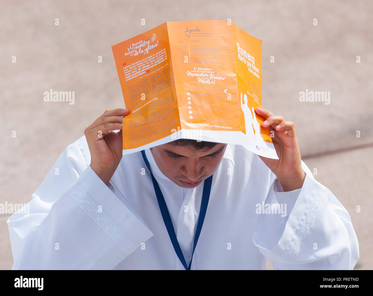 A novice priest shades himself from the tropical sun as El Salvador ...
