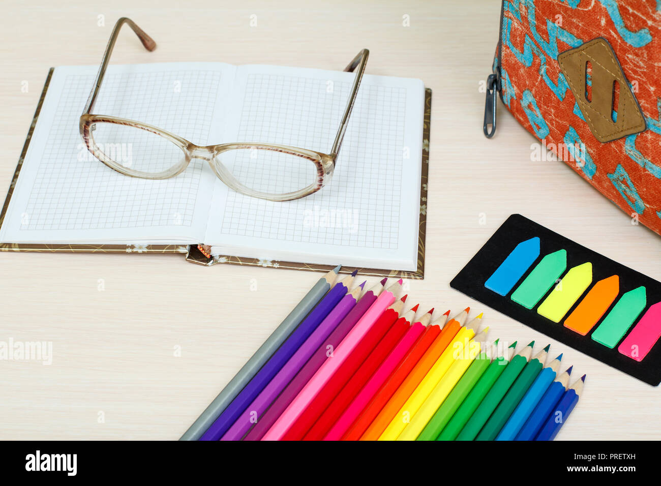 School supplies. School backpack, color pencils, notebook with glasses ...