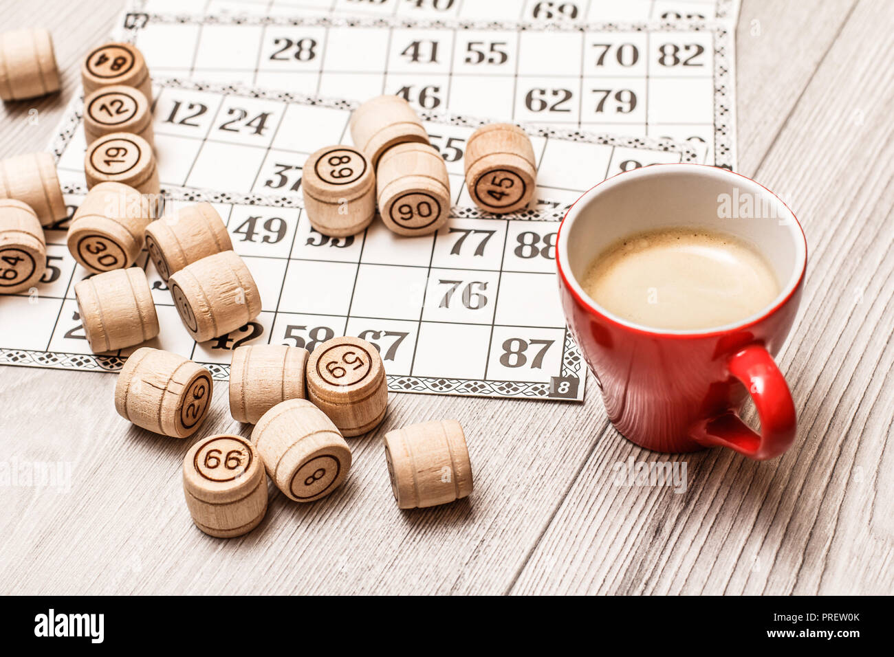 Board game lotto on white desk. Wooden lotto barrels and game cards for ...