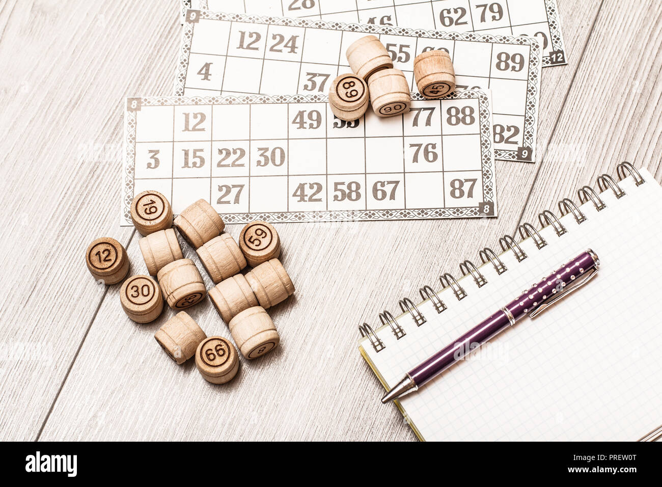 Board game lotto on white desk. Wooden lotto barrels and game cards for ...