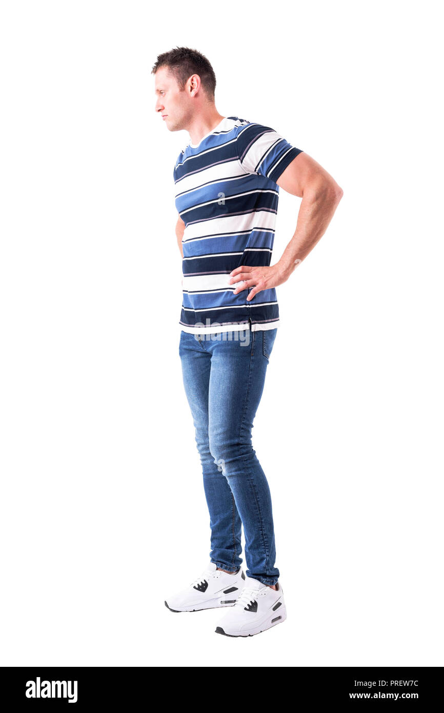 Profile of confident serious young casual fit man with hands on hips ...