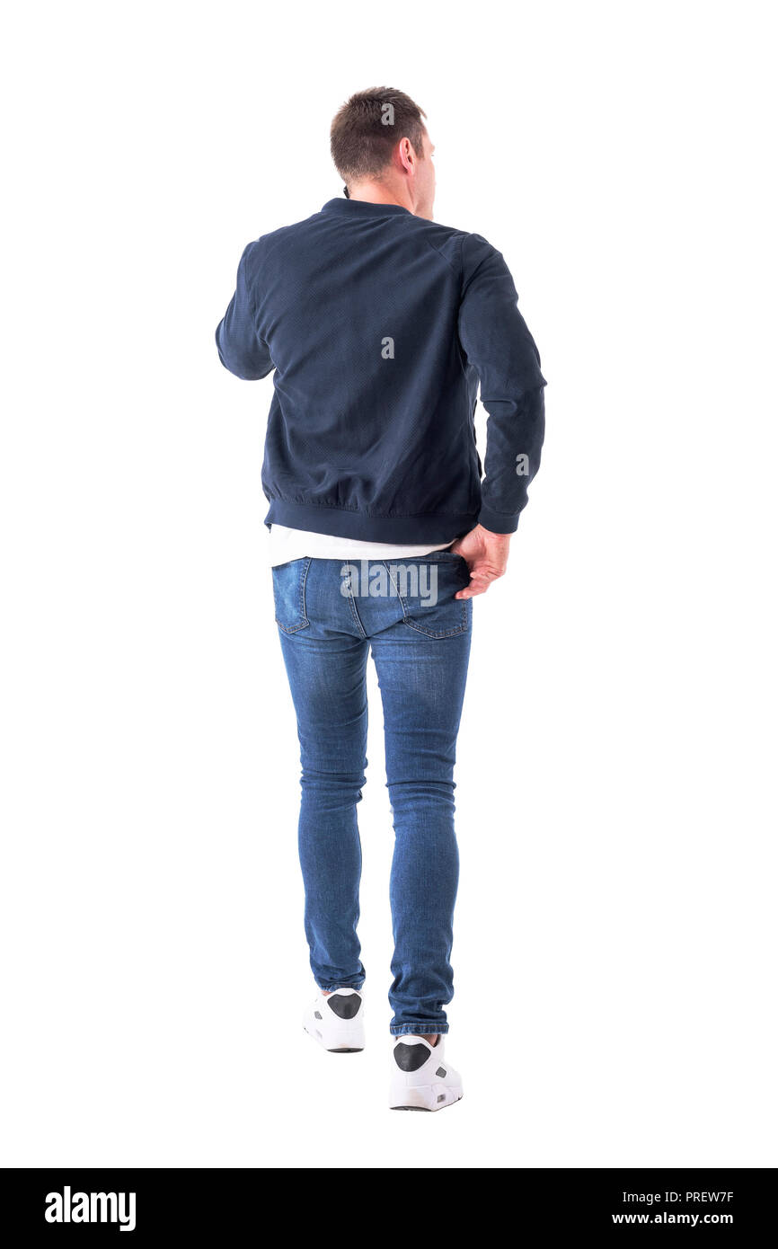 Back view of young man standing and talking on the mobile phone looking ...