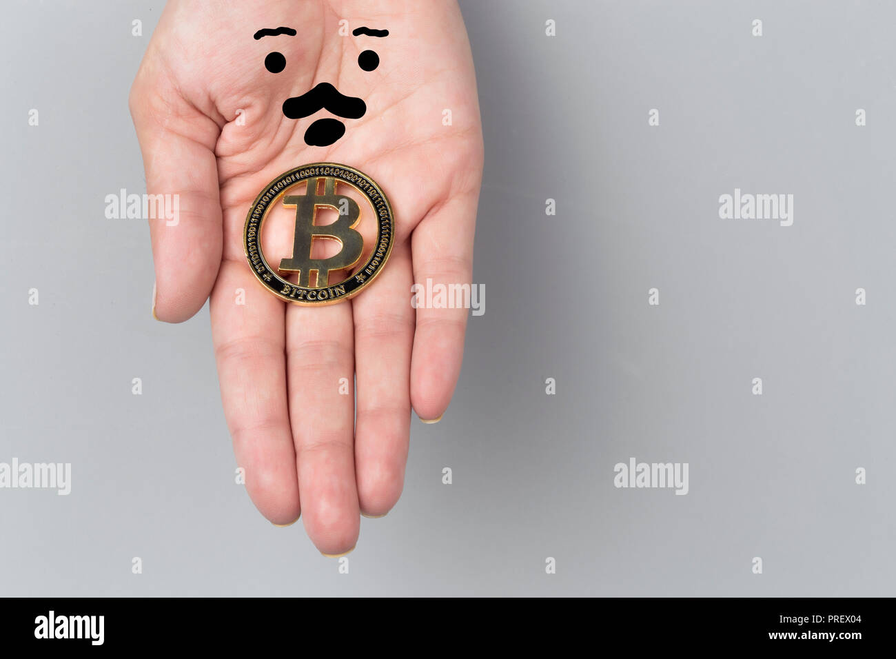golden bitcoin on the hand with a painted face on top, background image ...