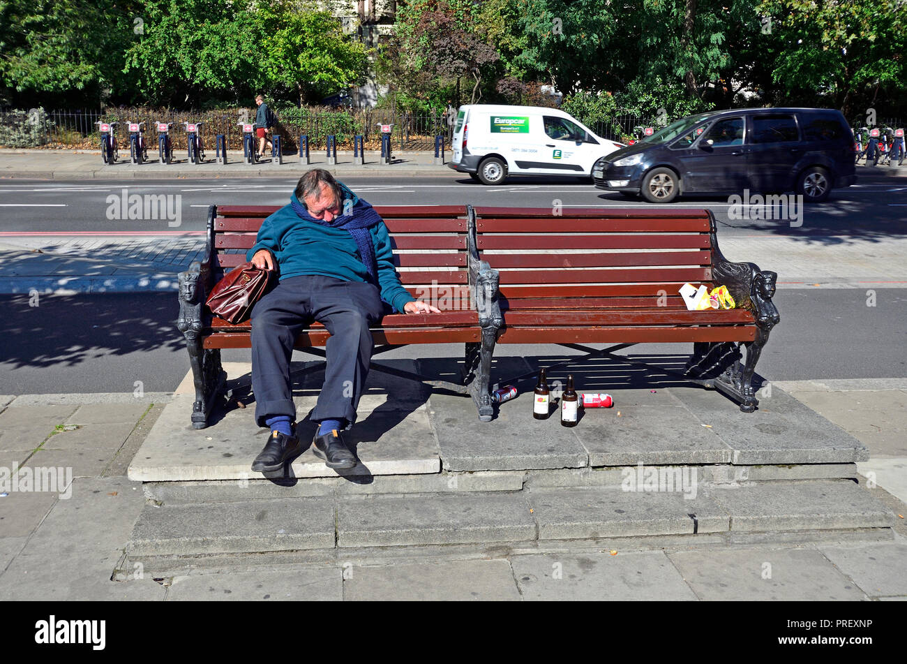 Man asleep on a bench with empty bottles. Victoria Embankment, London ...