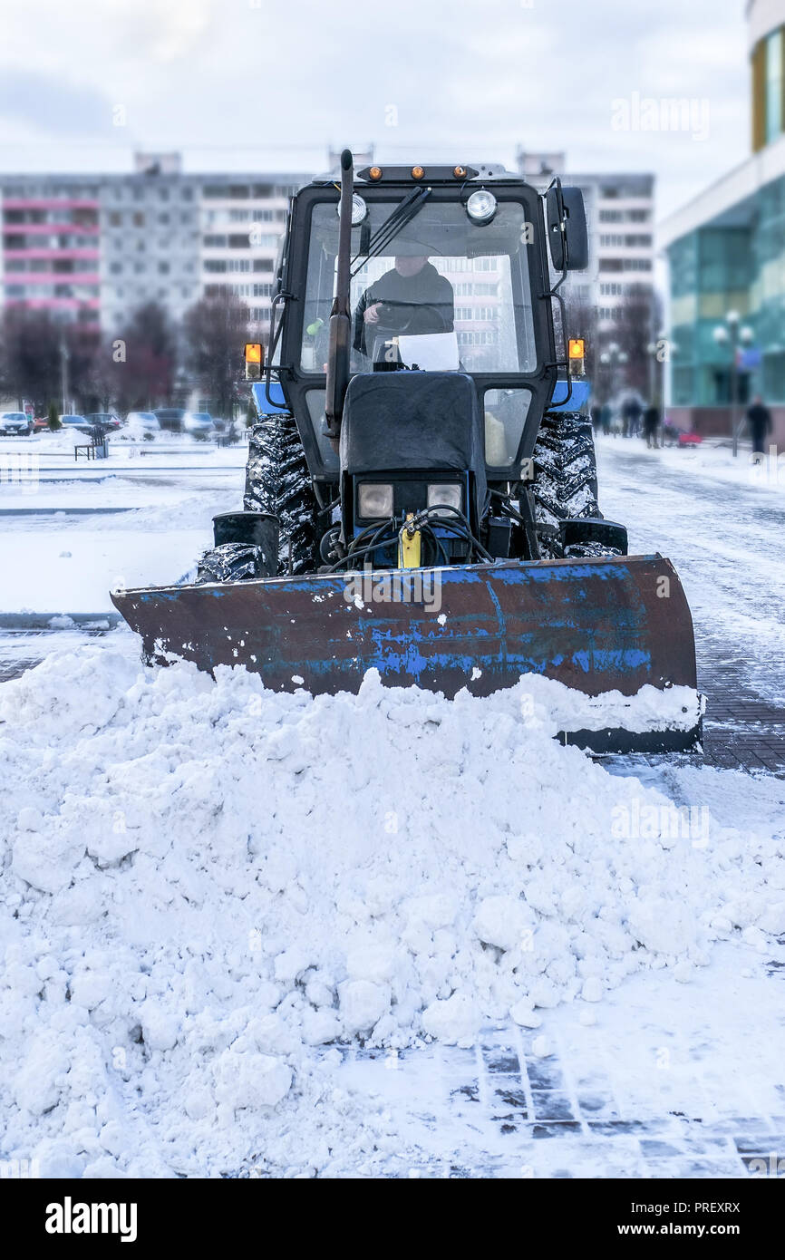 Blue bulldozer cleans the streets after a heavy natural snowfall Stock ...