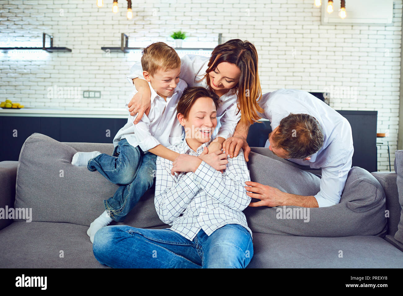 Happy family having fun playing together on a couch Stock Photo - Alamy