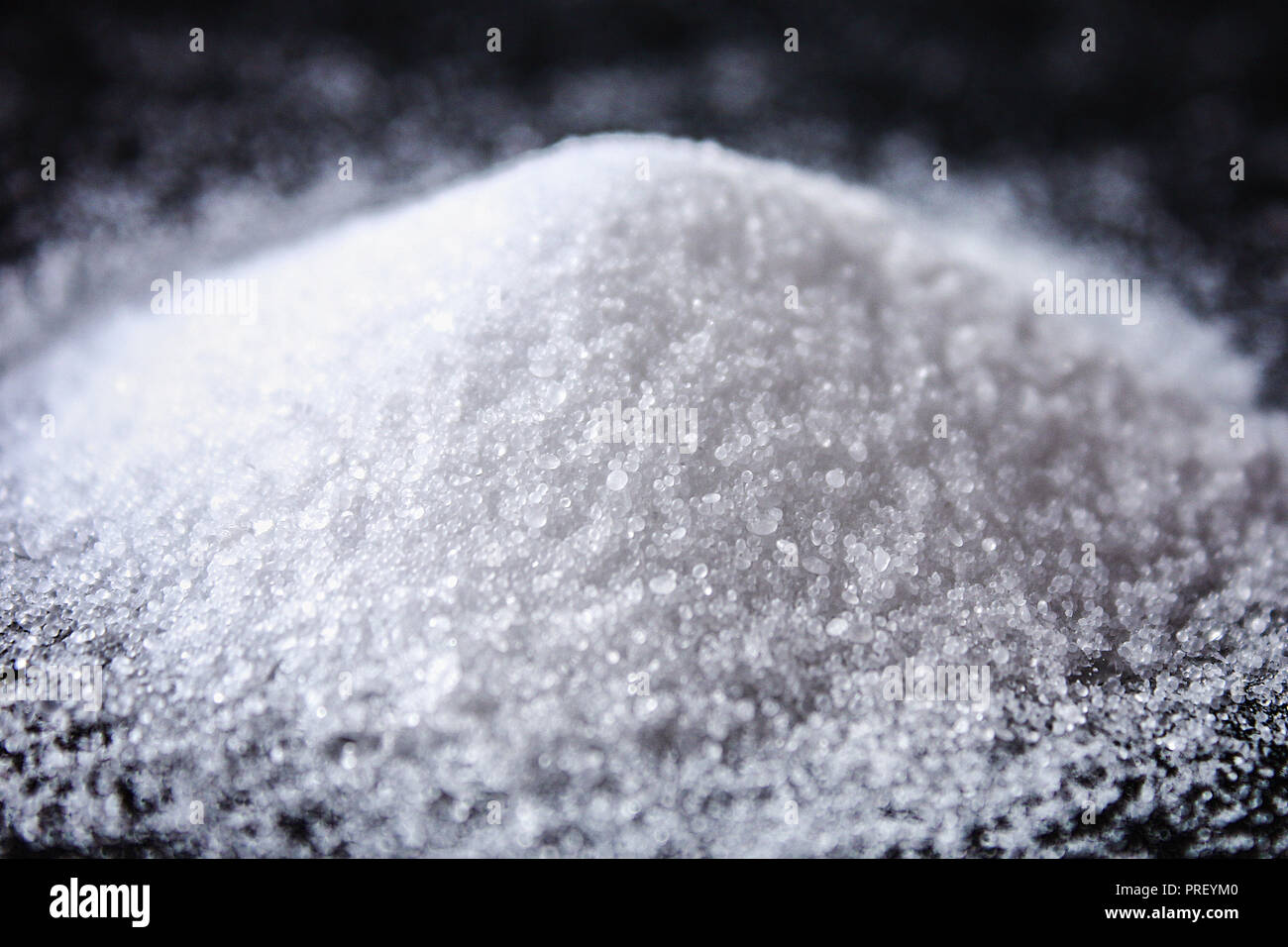 Slides of small crystals of salt are scattered on a black table Stock ...