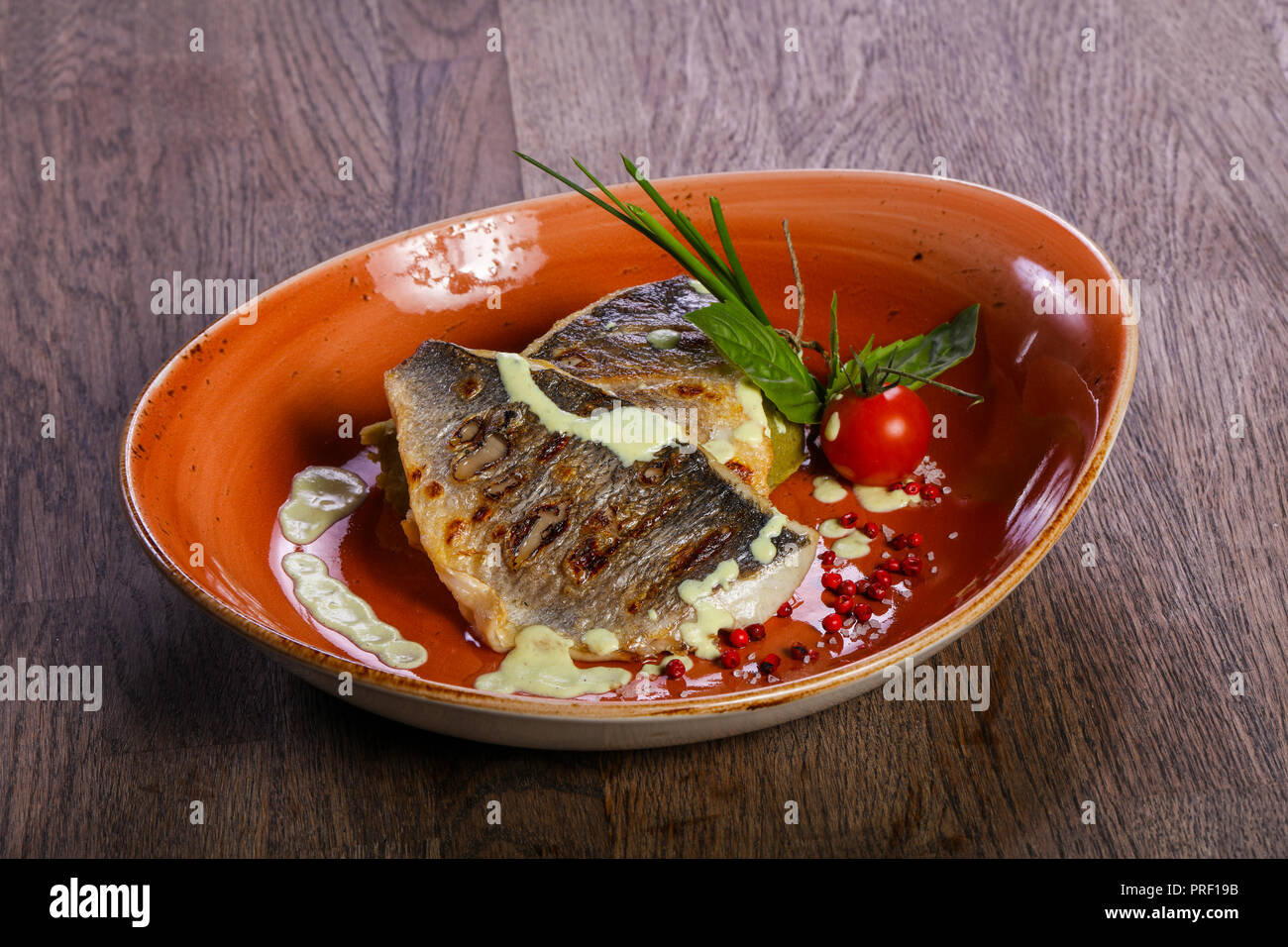 Grilled dorada fillet served tomato and onion Stock Photo - Alamy