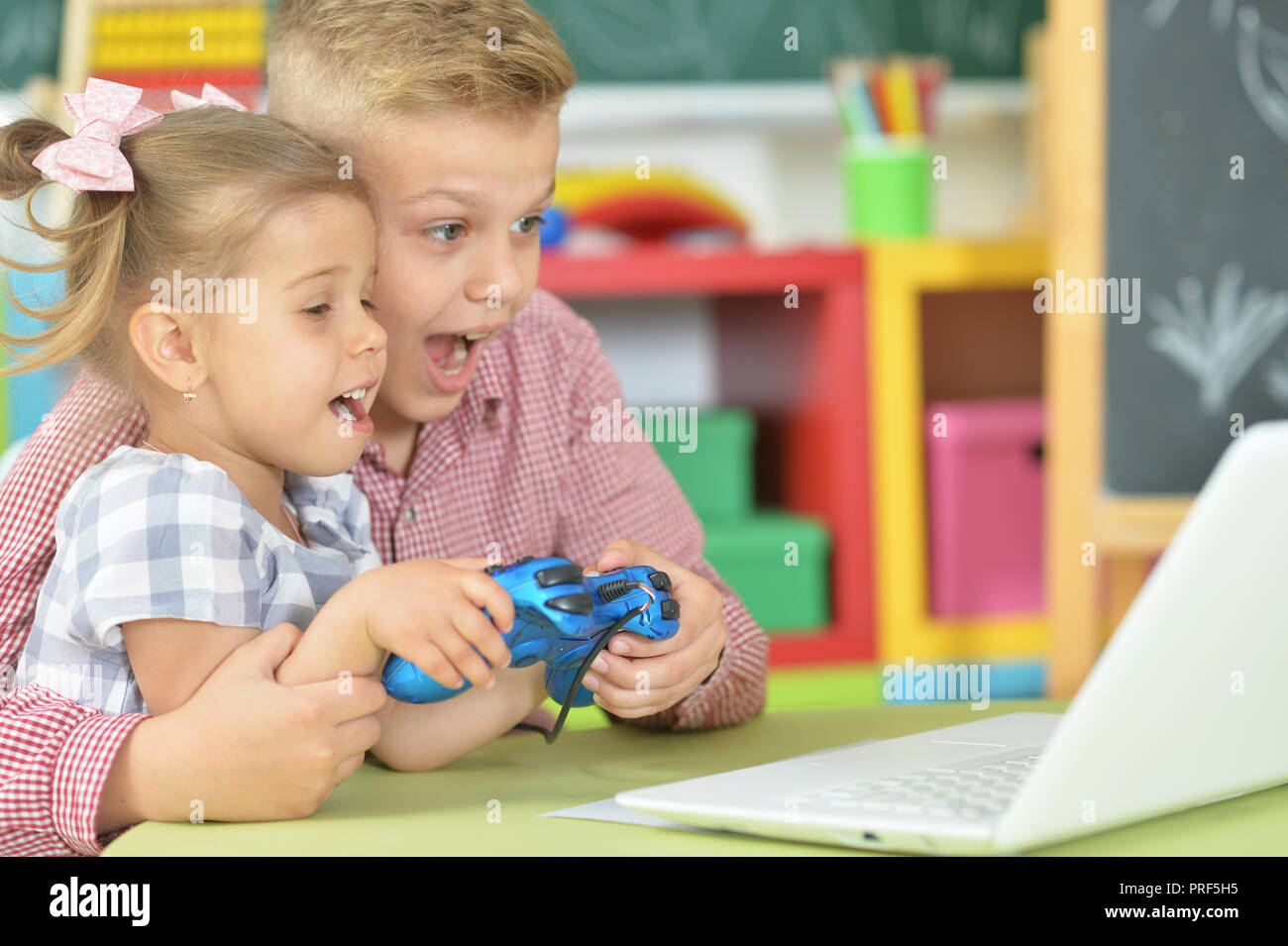Brother and sister playing computer game with joystick Stock Photo - Alamy