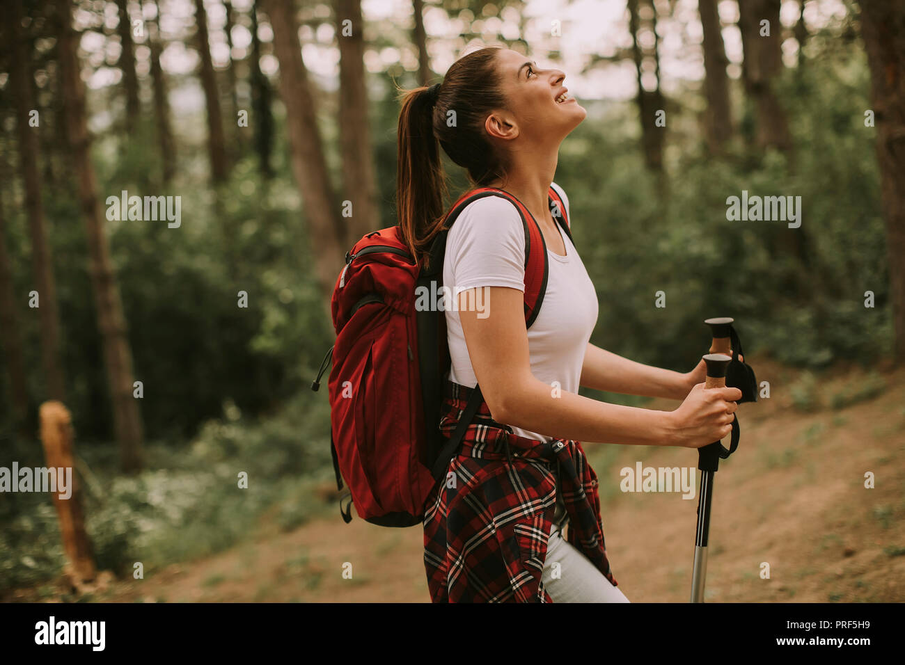 Side view at happy woman hiking in the forest Stock Photo - Alamy