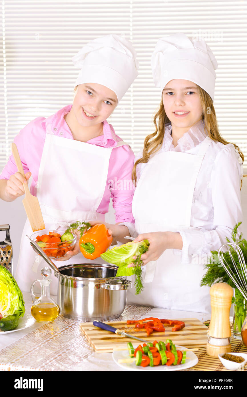 Two cute girls cooking on kitchen Stock Photo - Alamy