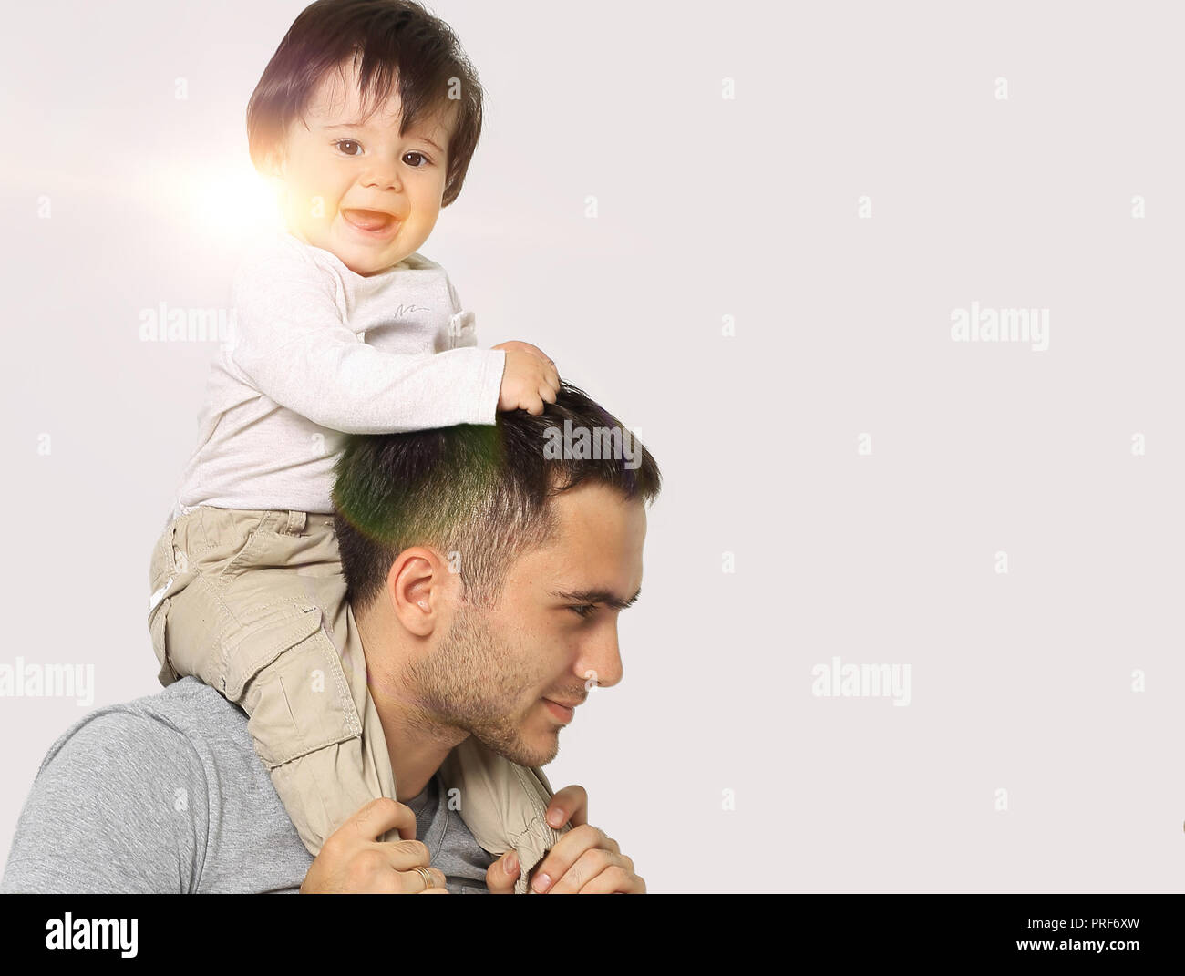 the little boy is sitting on the shoulders of Dad Stock Photo - Alamy
