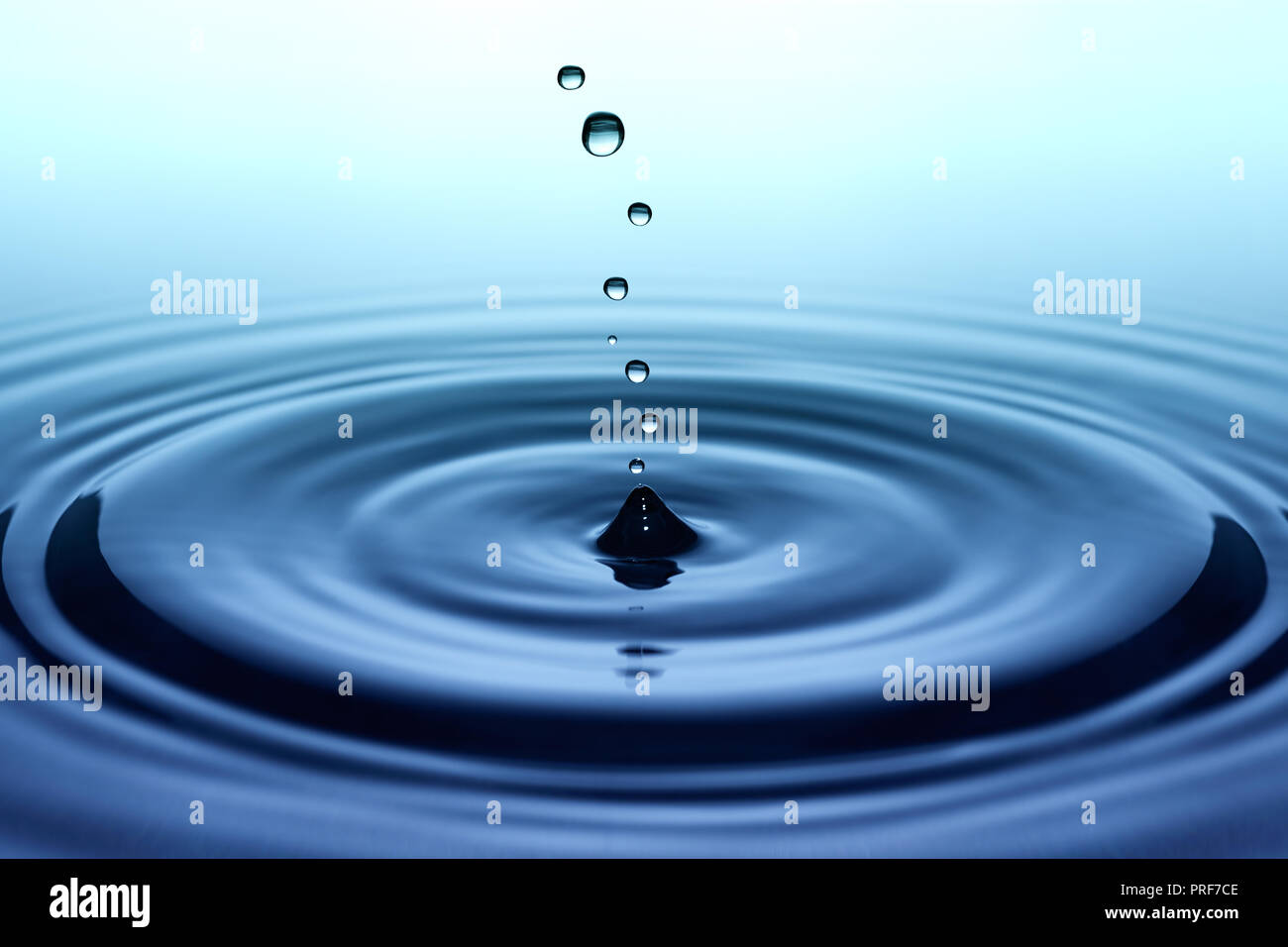 Splash. Rain drops falling on smooth surface of water Stock Photo - Alamy