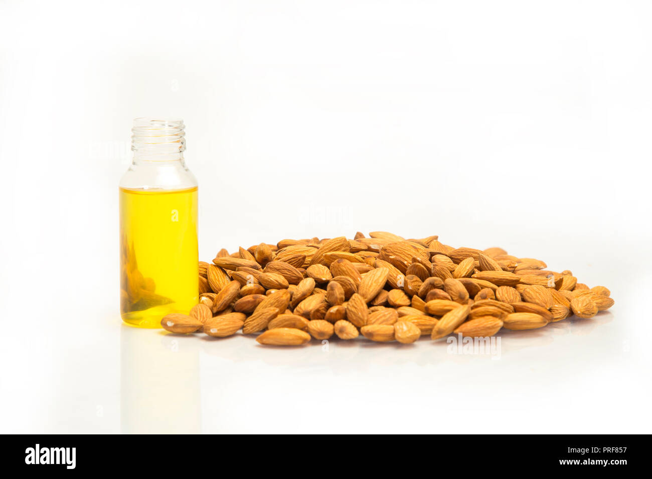 Almond nut heap and almond oil or roghan isolated on white background ...