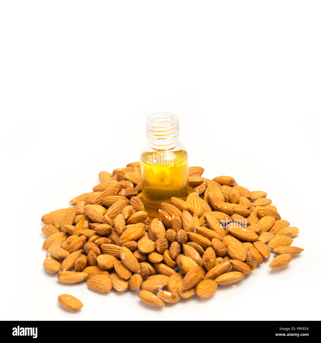 Almond nuts heap, almond oil / roghan isolated on white background ...