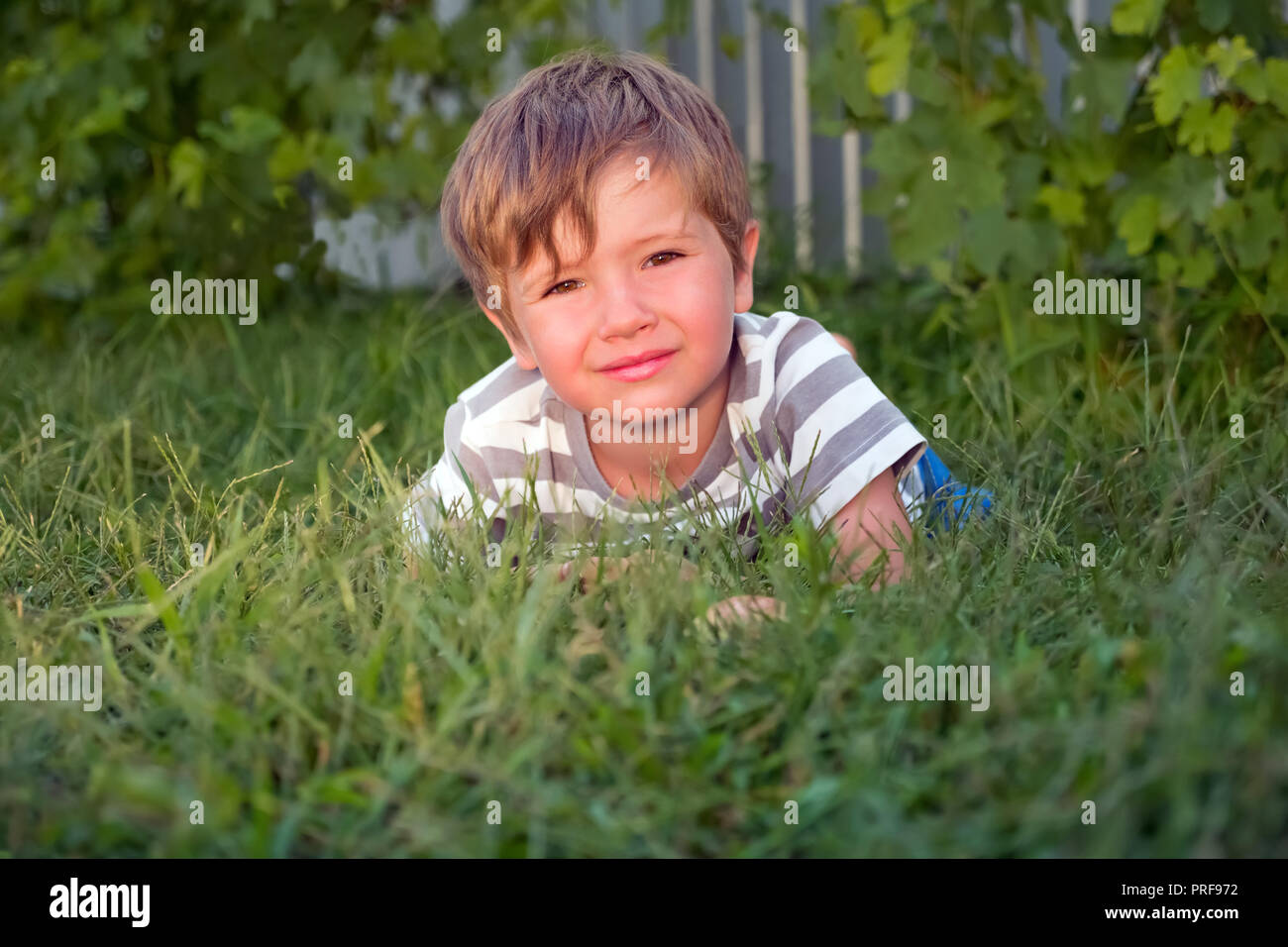 Cute kid having outside activities. Child on the grass Stock Photo - Alamy