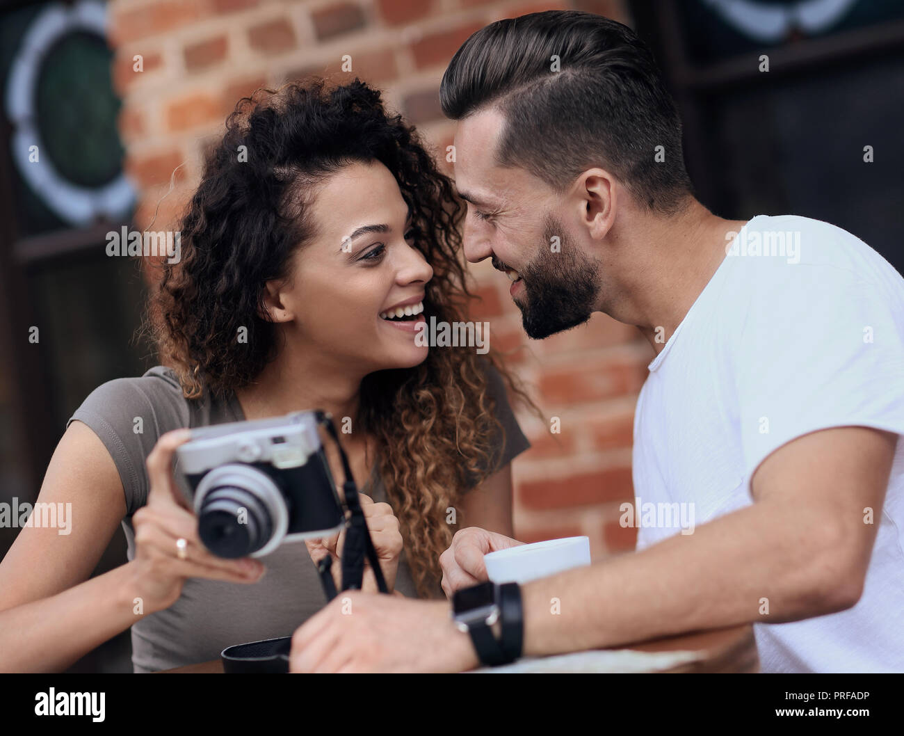 Portrait of a couple sitting down at a cafe and looking photos Stock ...