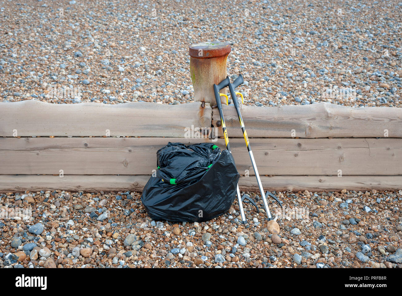 Beach clean up. A black bag full of rubbish collected from the beach ...