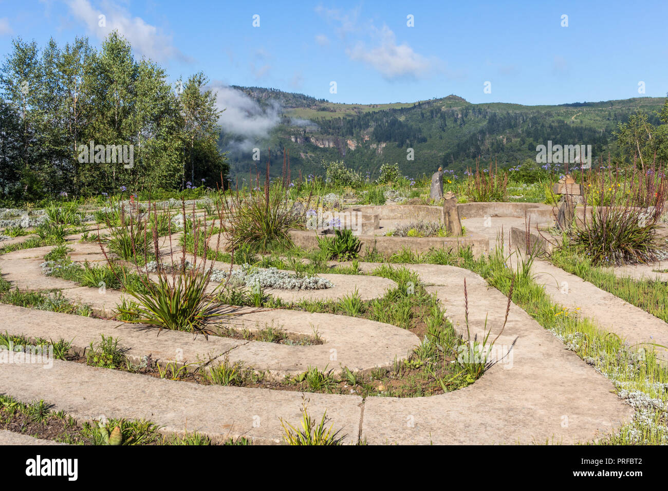 Maze concrete pathway of a labyrinth on the edge of misty valley in ...