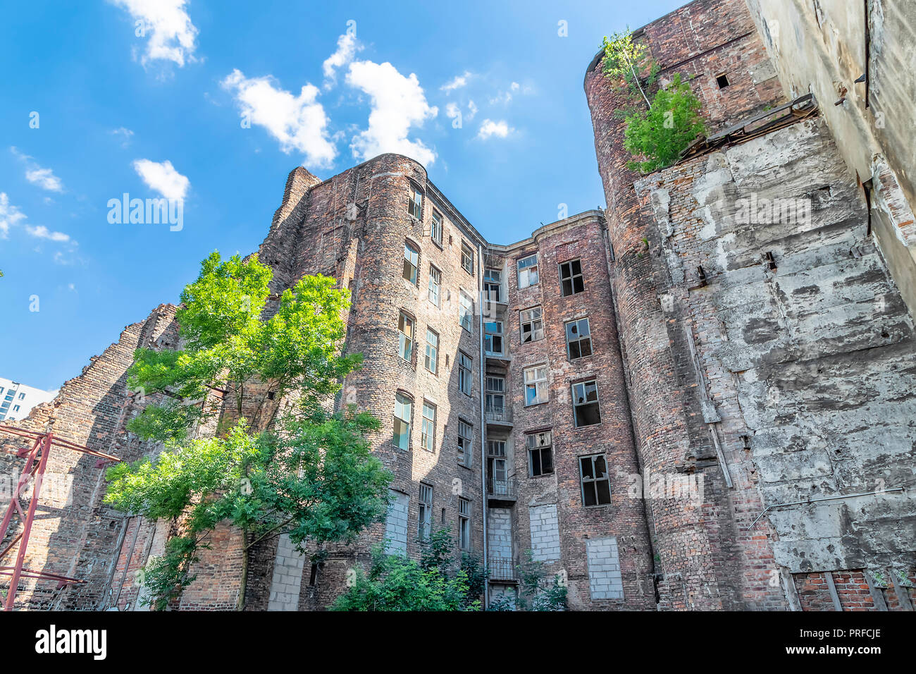 Facade of ruined old vintage red brick house with broken windows ...