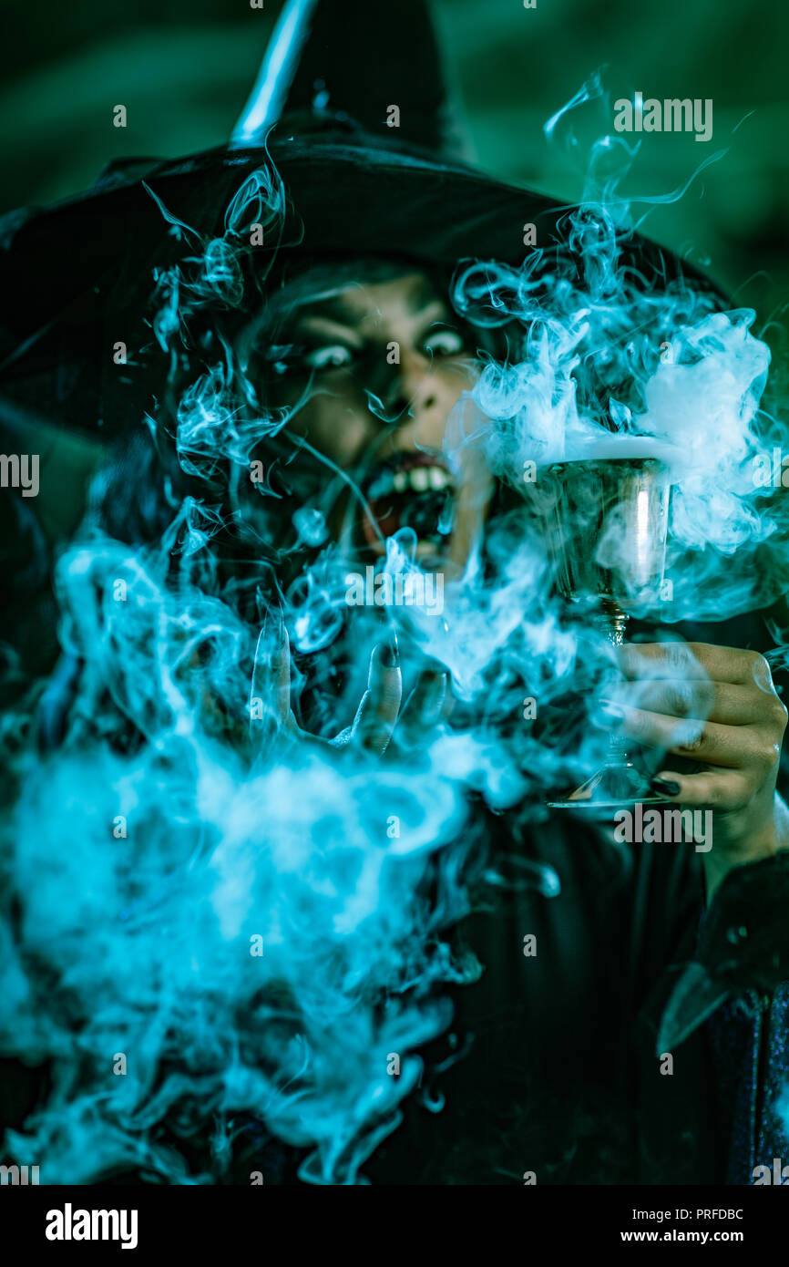 Portrait of witch with awfully face in creepy surroundings and smoky ...