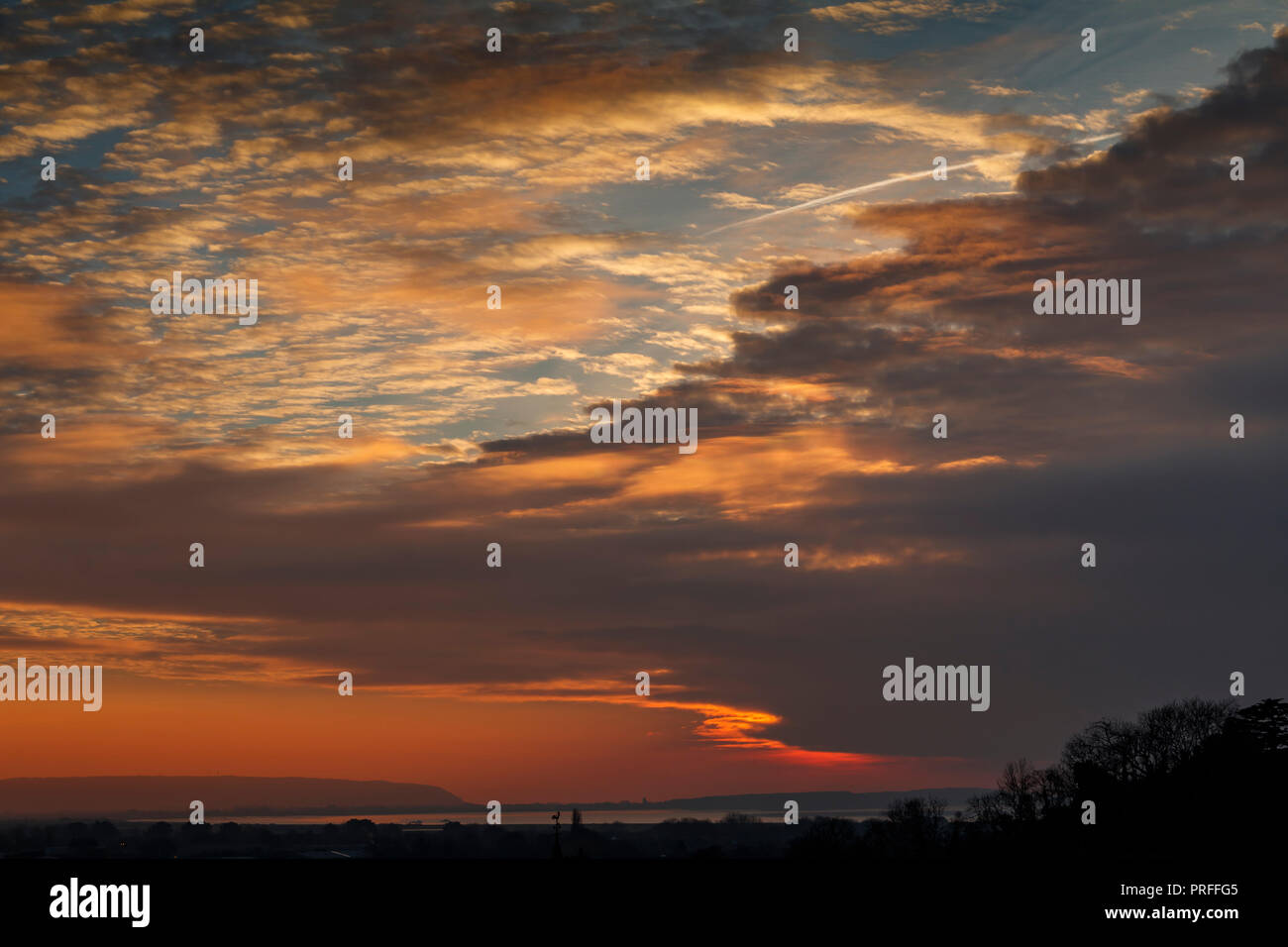 The setting sun lighting up the edge of the cloud-cover Stock Photo - Alamy