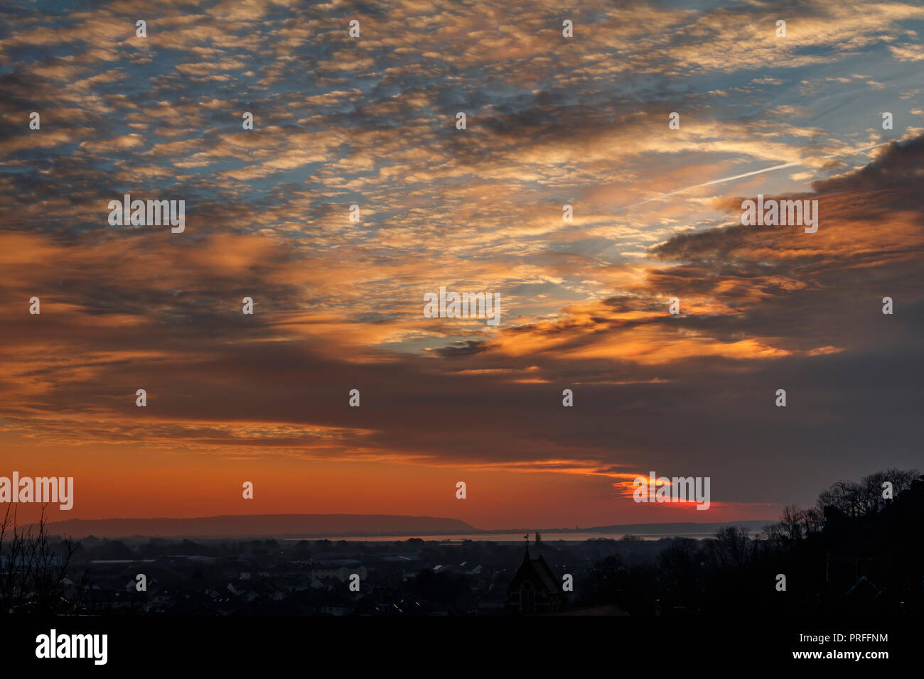The setting sun lighting up the edge of the cloud-cover Stock Photo - Alamy