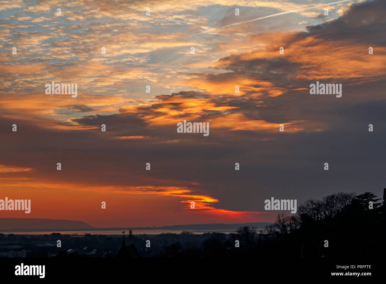 The setting sun lighting up the edge of the cloud-cover Stock Photo - Alamy