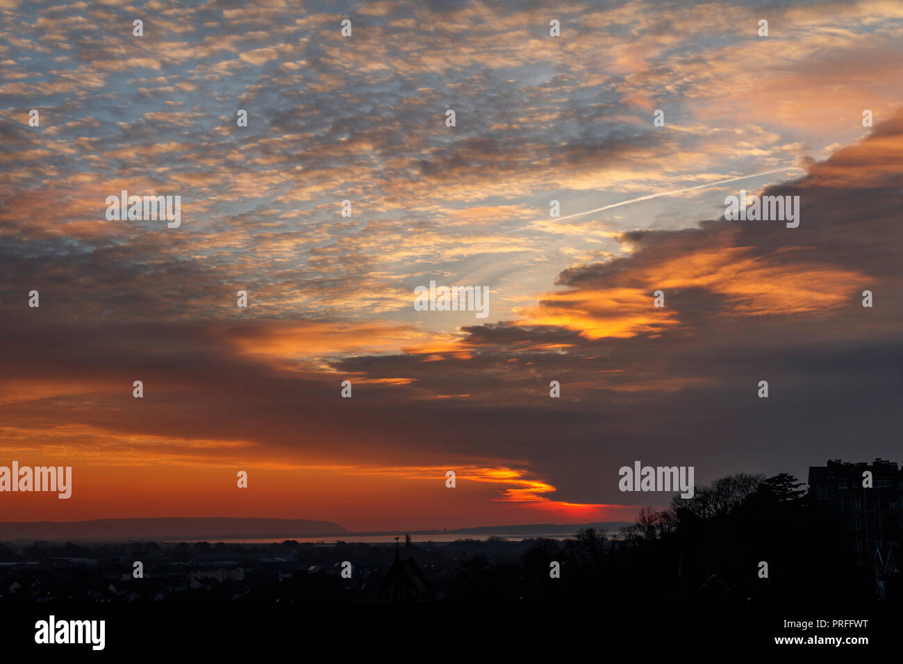 The setting sun lighting up the edge of the cloud-cover Stock Photo - Alamy