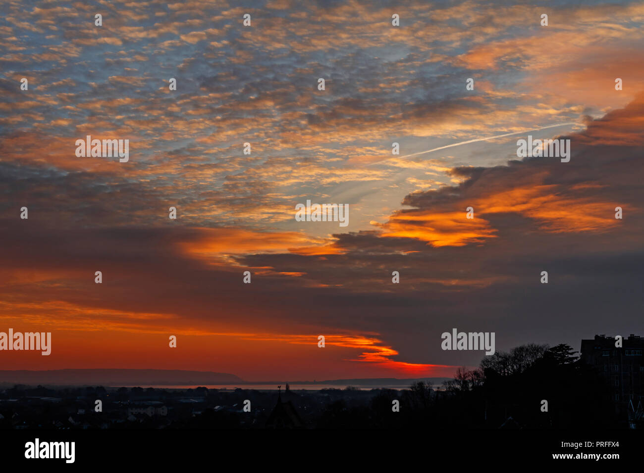 The setting sun lighting up the edge of the cloud-cover Stock Photo - Alamy