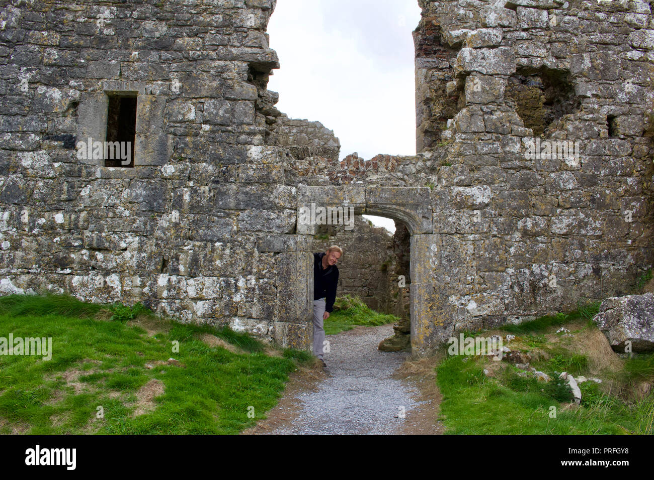 A man explores the stone entrance corridor of a medieval castle ruin in ...