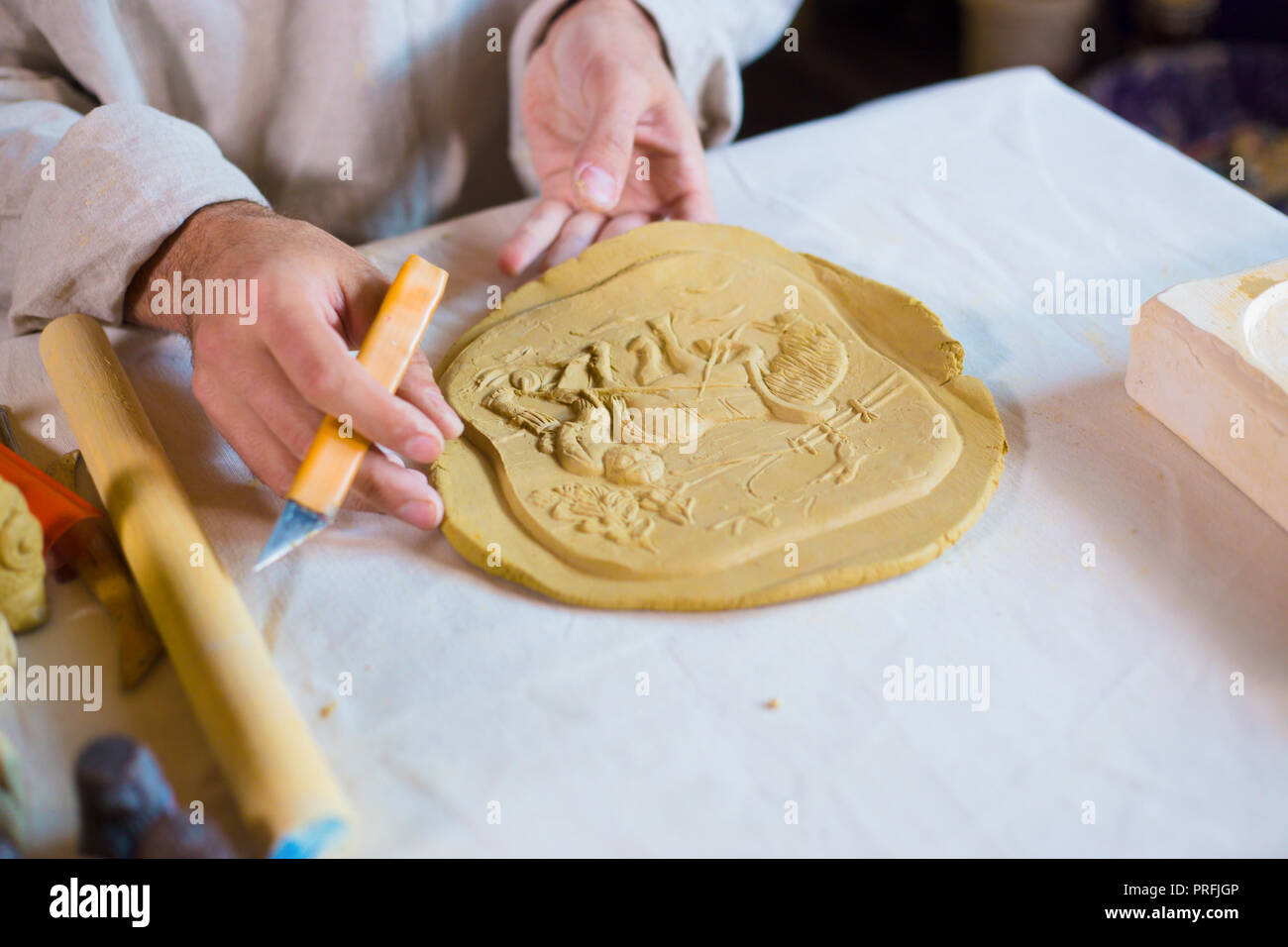 Professional male potter making clay stamp picture. Handwork, crafting ...