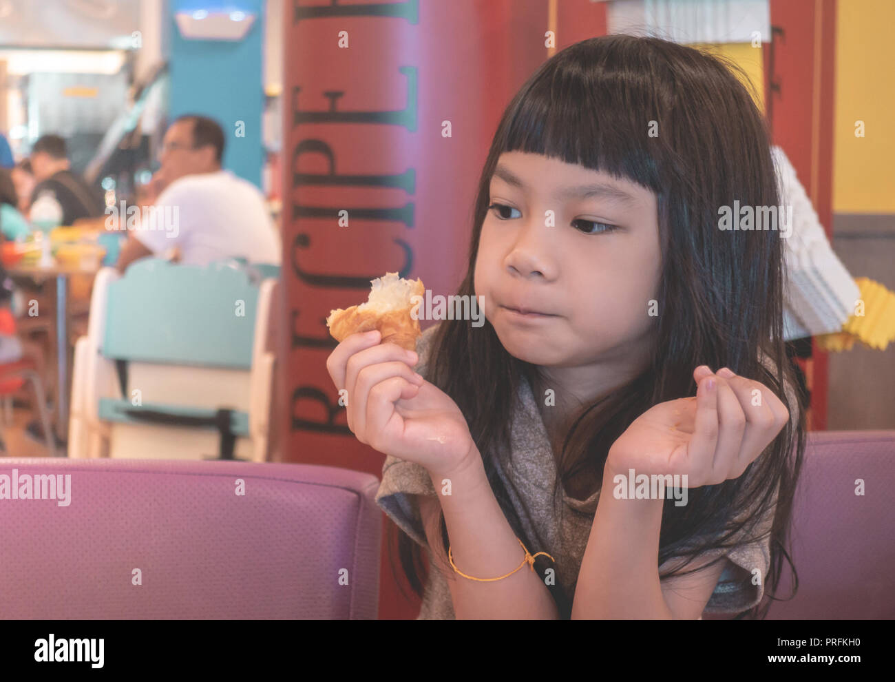 Asian girl eating croissant in italian restaurant Stock Photo - Alamy